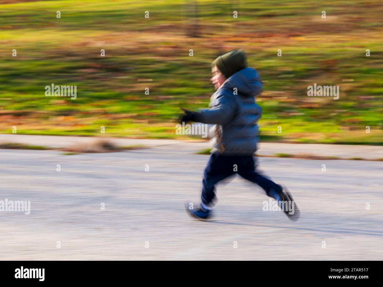 Autumn pan motion blur of young boy running on playground; Philadelphia ...