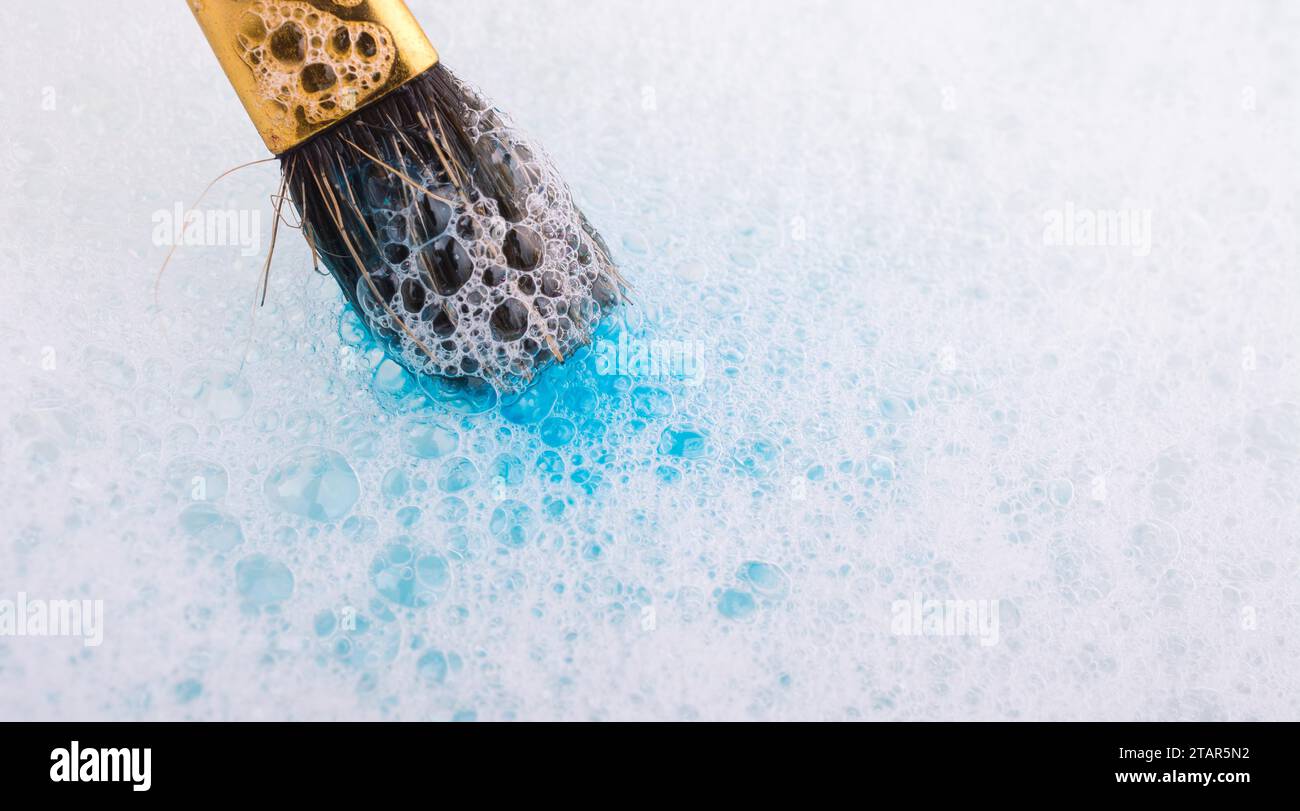 Paint dissolving in water as painting brush touching water Stock Photo ...
