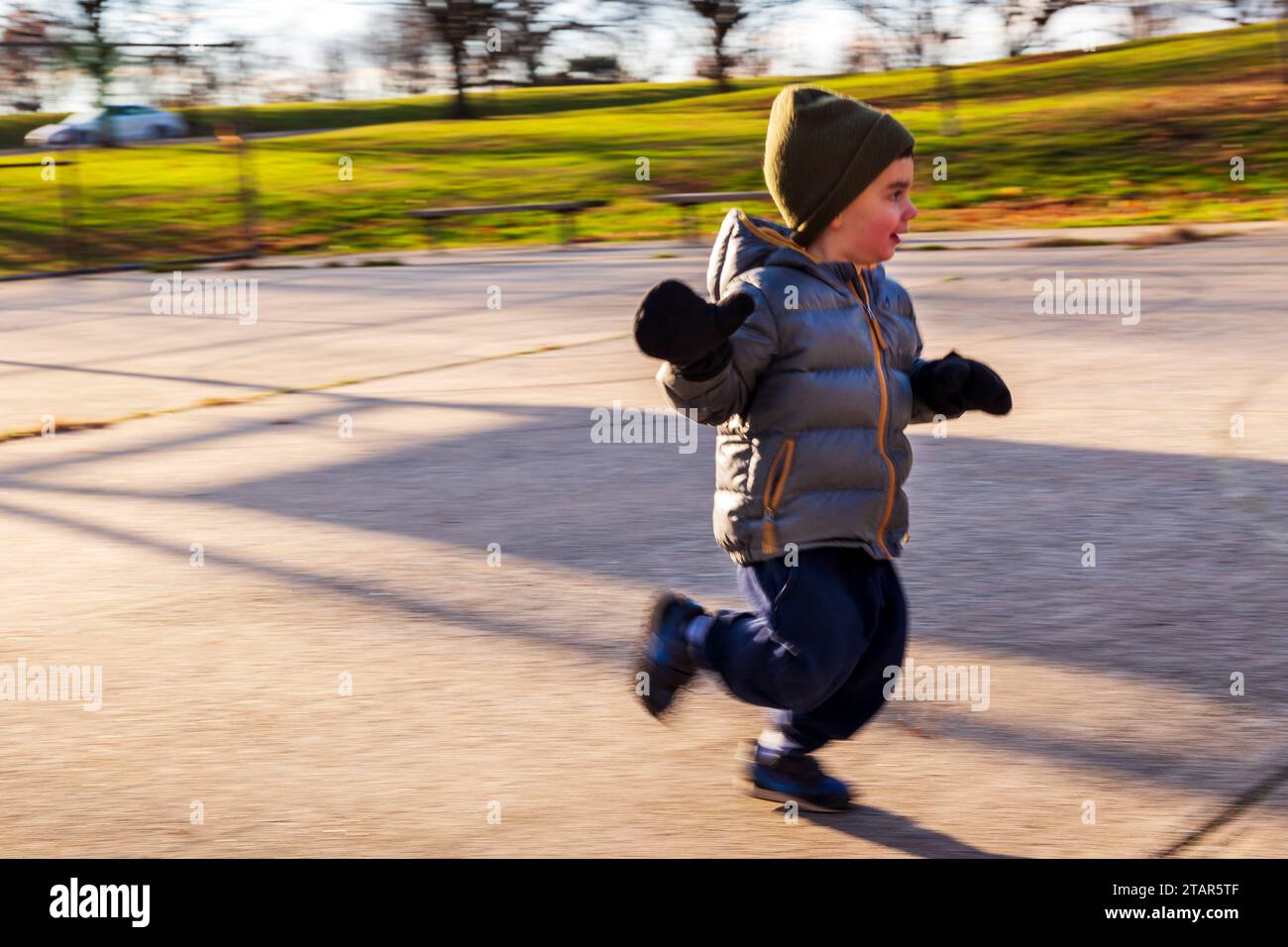 Autumn pan motion blur of young boy running on playground; Philadelphia ...