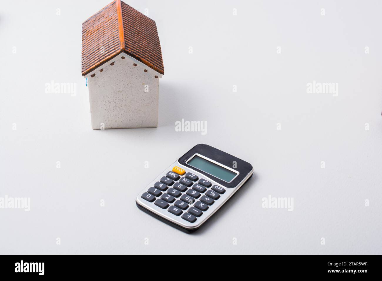 Model house and calculator placed on white background Stock Photo - Alamy