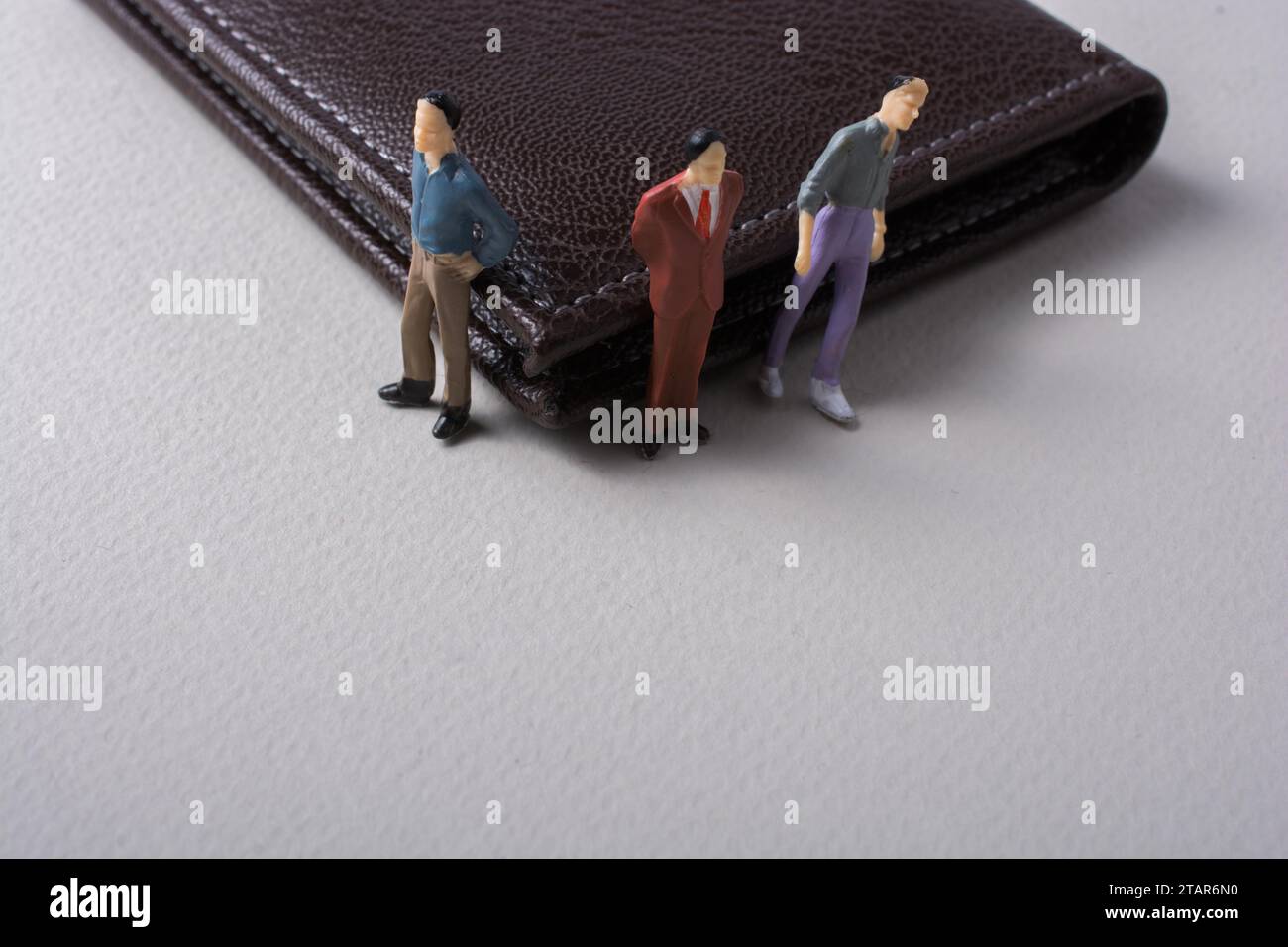 Tiny figurine of men miniature model beside a wallet Stock Photo - Alamy
