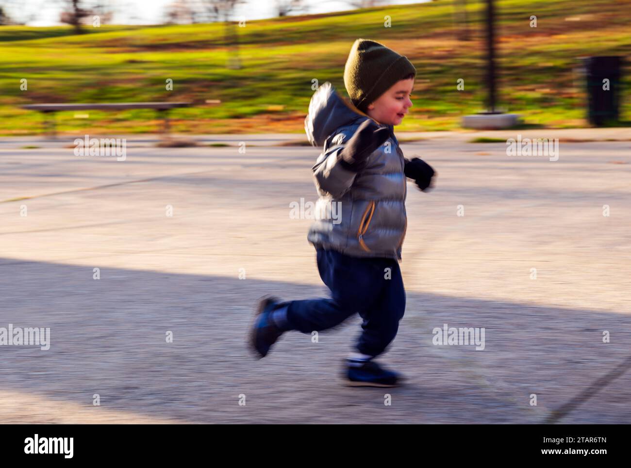 Autumn pan motion blur of young boy running on playground; Philadelphia ...