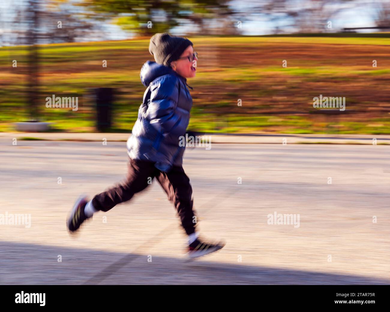 Autumn pan motion blur of young boy running on playground; Philadelphia ...