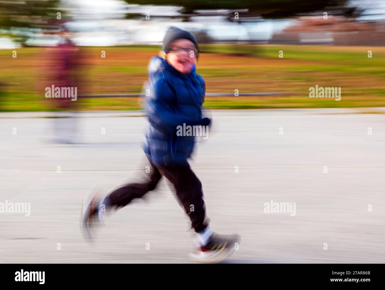 Autumn pan motion blur of young boy running on playground; Philadelphia ...