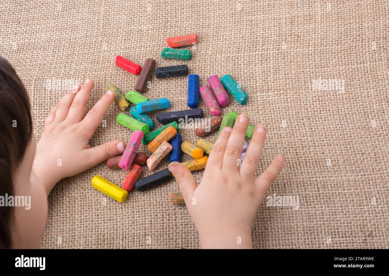 Used color crayons and a toddlers hand holding one Stock Photo - Alamy