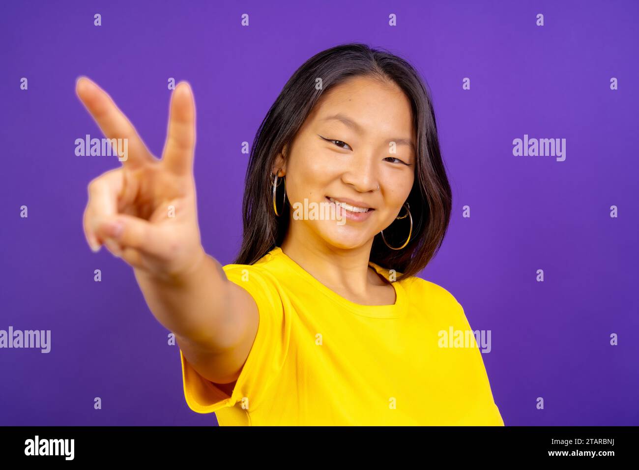 Studio photo with purple background of a smiling chinese woman ...