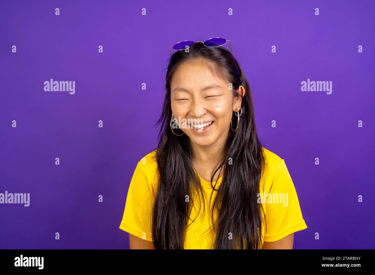 Studio photo with purple background of a chinese woman laughing with ...
