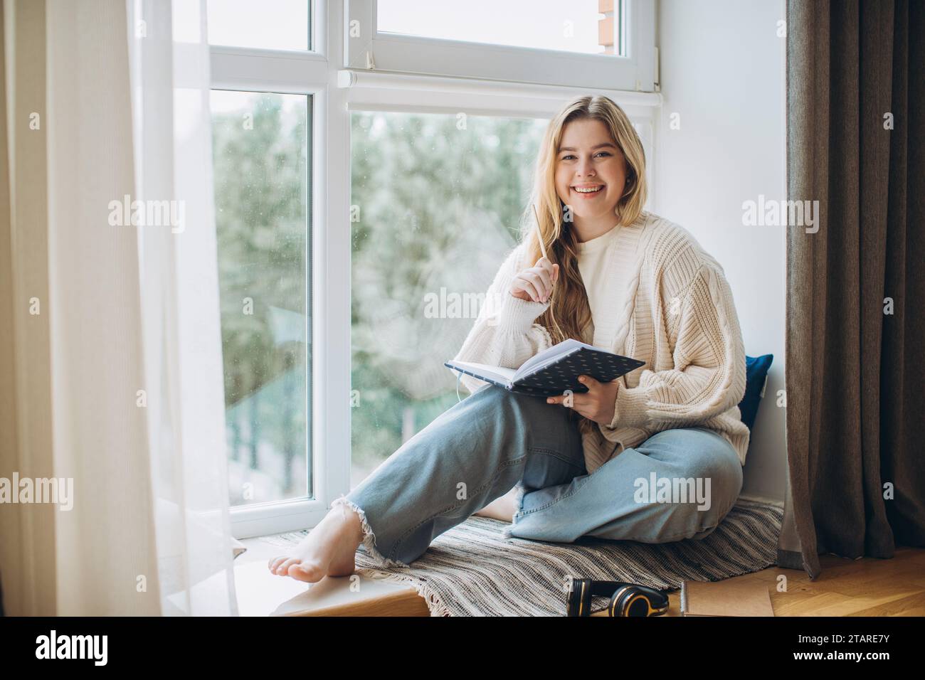 Creative young woman writes memory plan and idea in notebook while ...