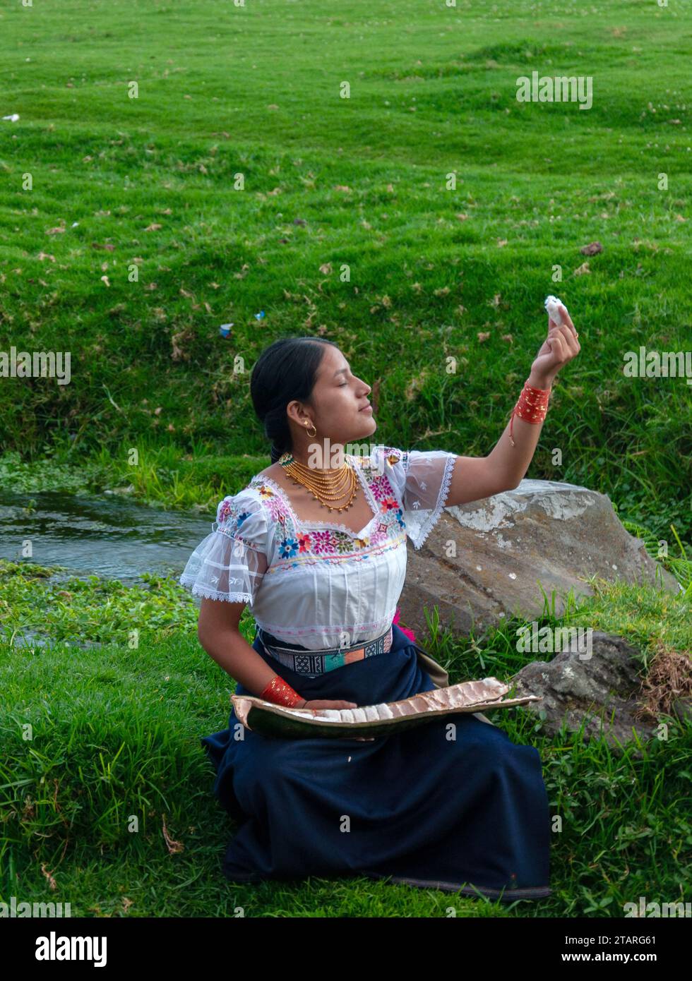 young indigenous girl making an offering to mother nature of the first ...