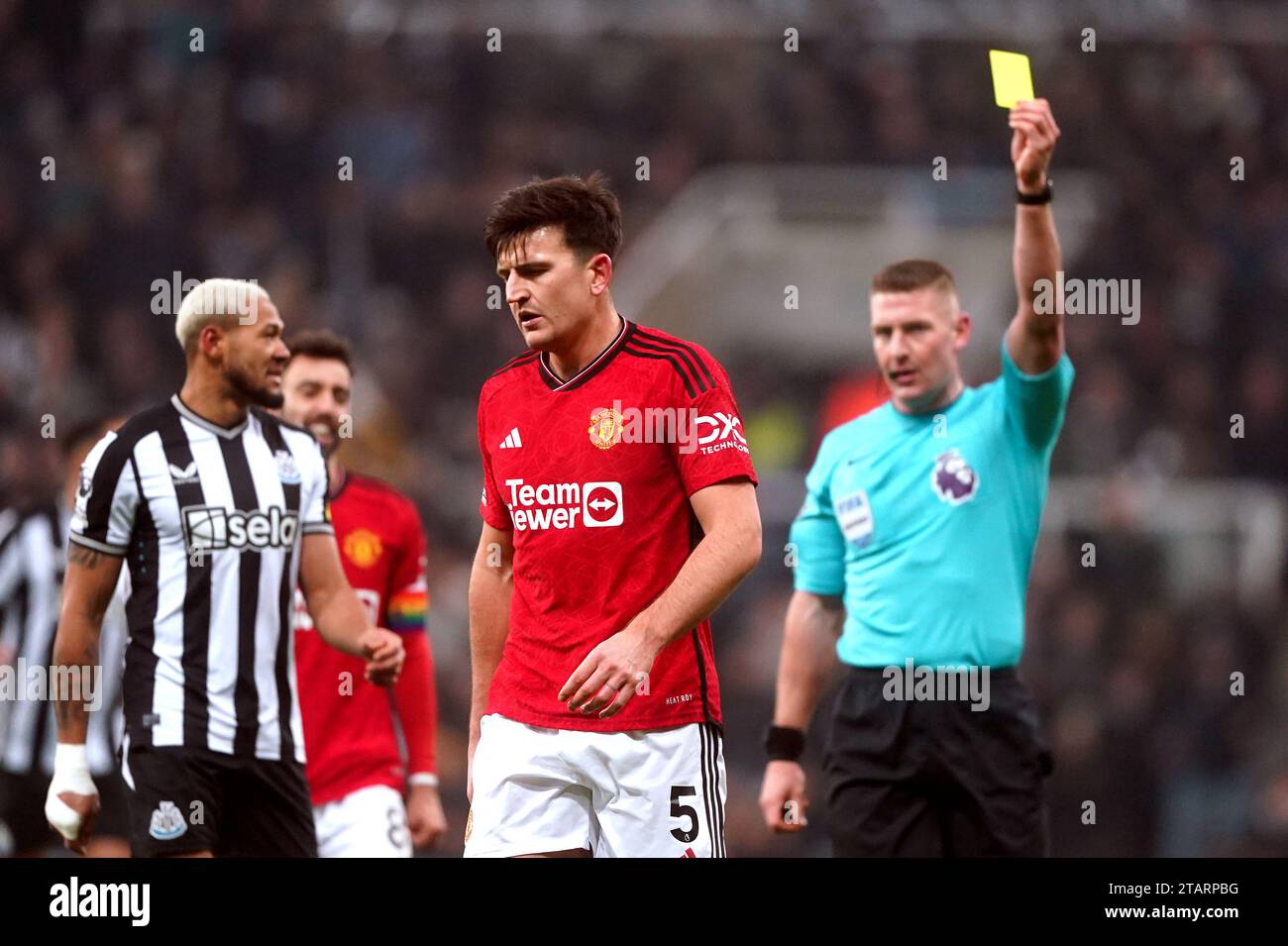 Referee Robert Jones (right) shows a yellow card to Manchester United's ...