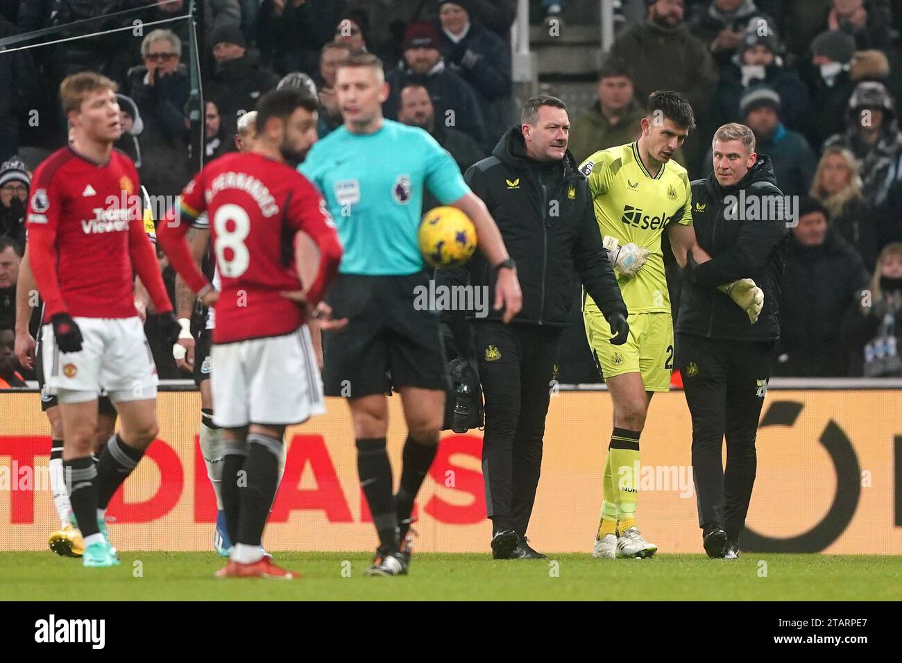 Newcastle United goalkeeper Nick Pope (second right) is helped off the ...