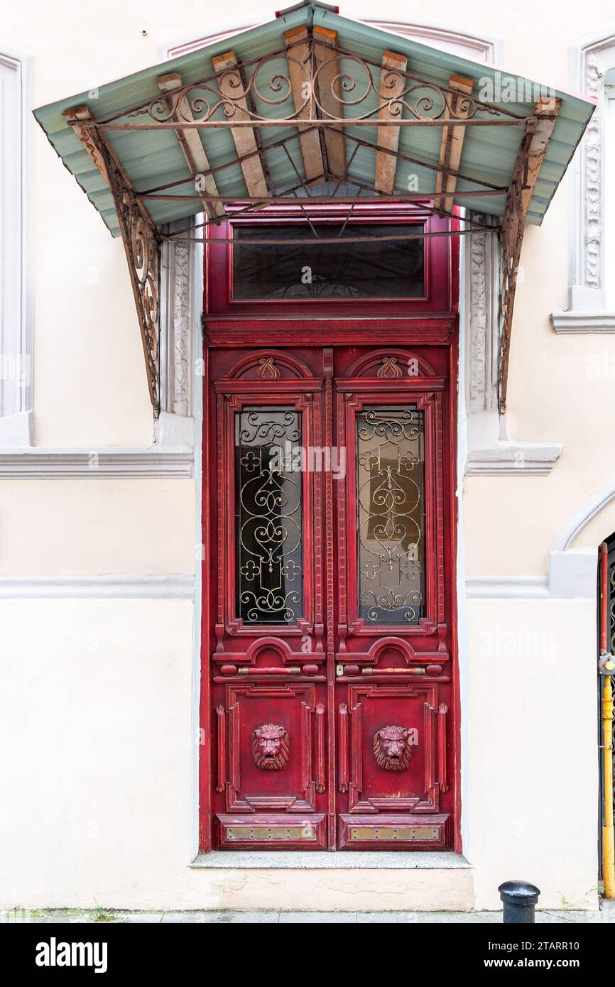 travel to Georgia - old red entrance door of urban apartment building ...