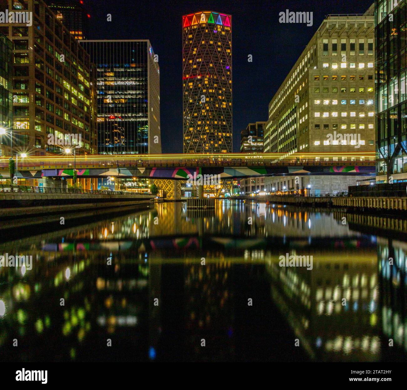 Night time at Canary Wharf and Middle Dock surrounded by sky scrapers ...