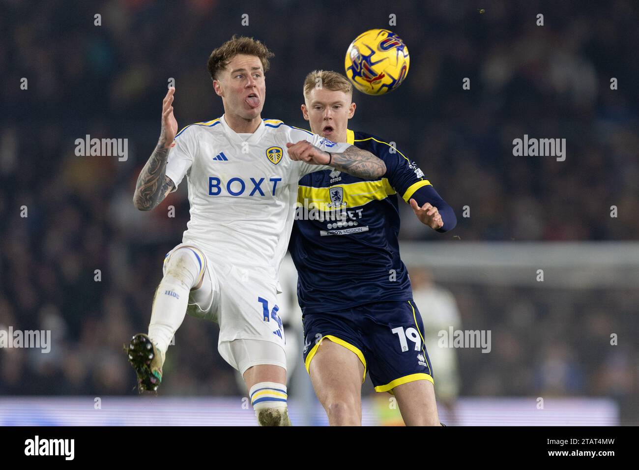 Joe Rodon of Leeds United wins the ball ahead of Josh Coburn of ...