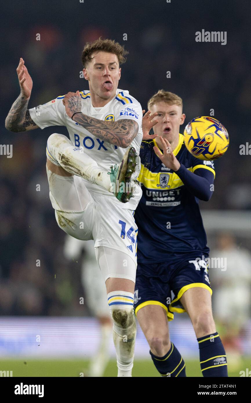 Joe Rodon of Leeds United wins the ball ahead of Josh Coburn of ...