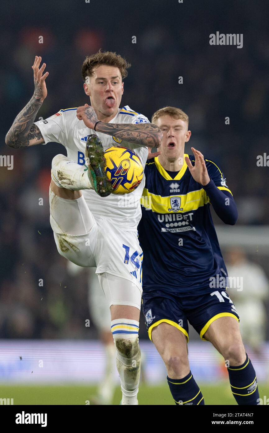 Joe Rodon of Leeds United wins the ball ahead of Josh Coburn of ...
