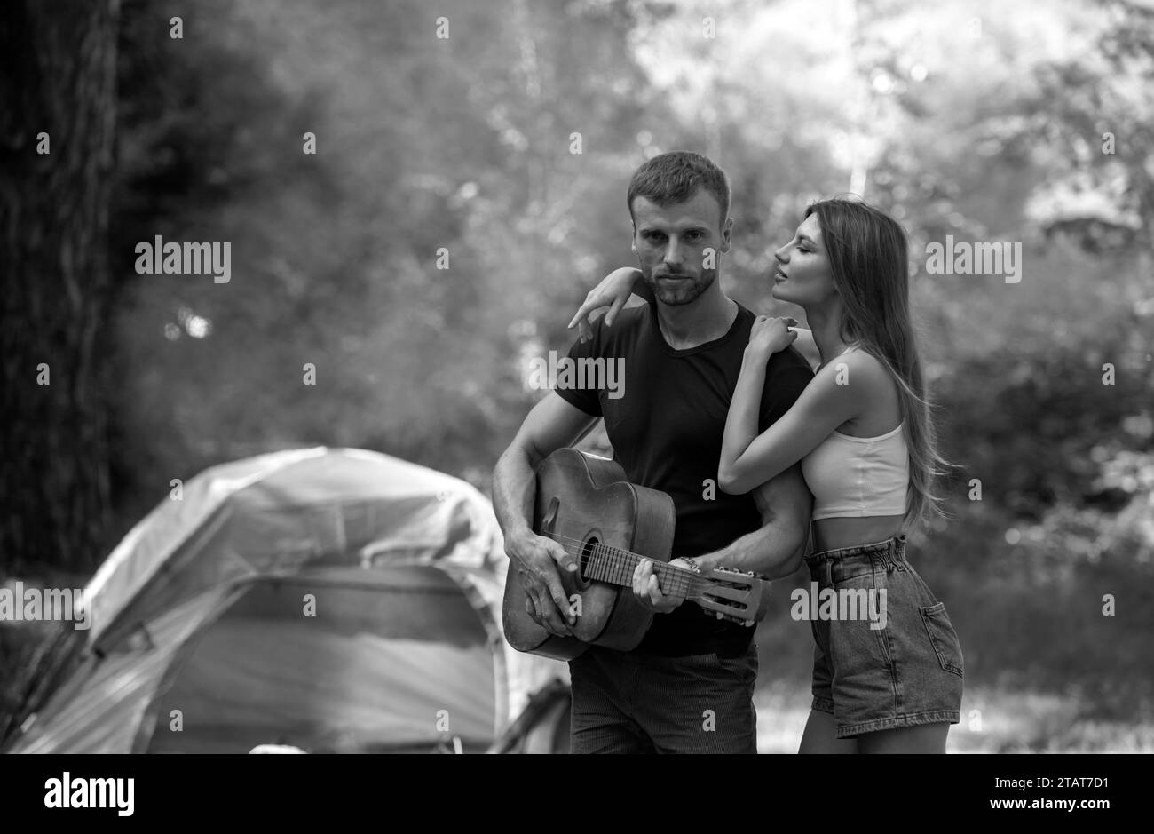 Romantic couple camping on spring landscape, man with guitar. Adventure ...
