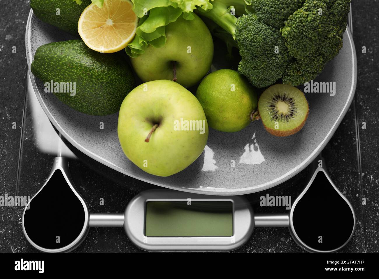 Healthy diet. Scale and fresh products on black textured table, top ...