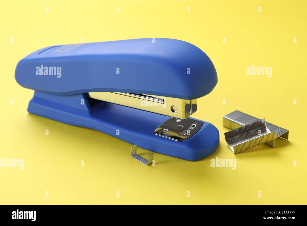 Blue stapler with staples on yellow background Stock Photo - Alamy