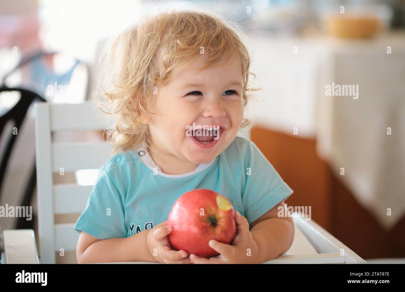 Laughing cute child eating apple. Cute baby eat apples. Portrait of ...