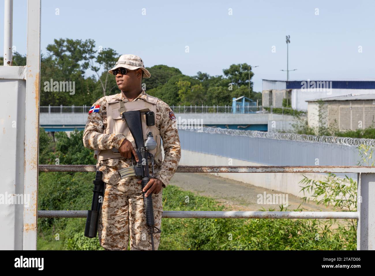 A soldier stands guard at the Dominican Republic and Haiti border ...