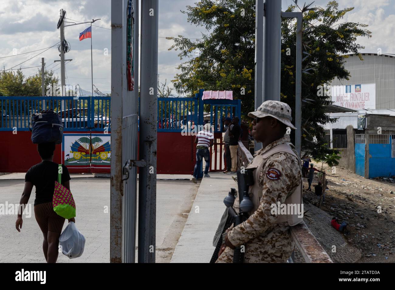 A soldier stands guard while Haitians cross the Dominican Republic and ...