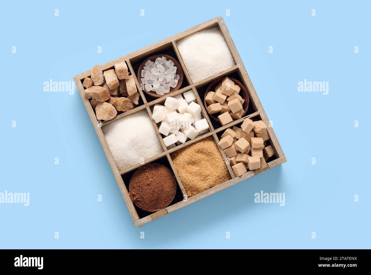 Wooden box with different types of sugar on blue background Stock Photo ...