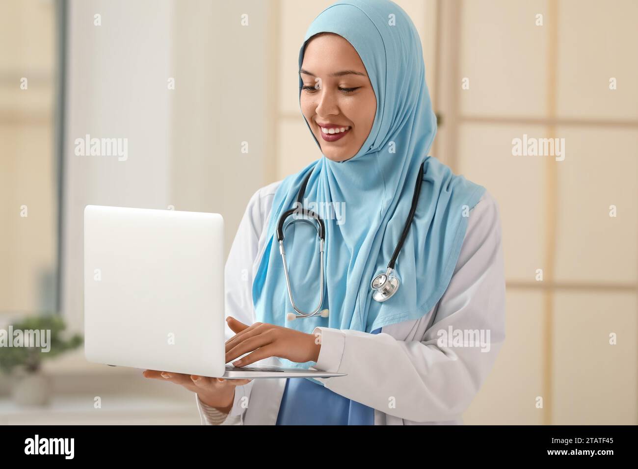 Female Muslim doctor in hijab with modern laptop at clinic. World Hijab ...
