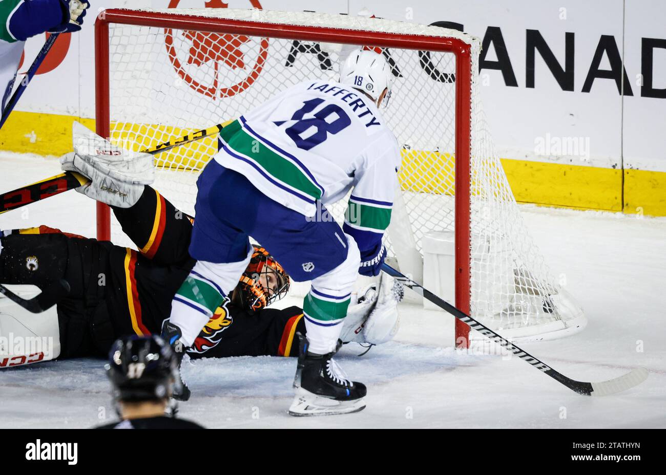 Vancouver Canucks forward Sam Lafferty, right, scores on Calgary Flames ...