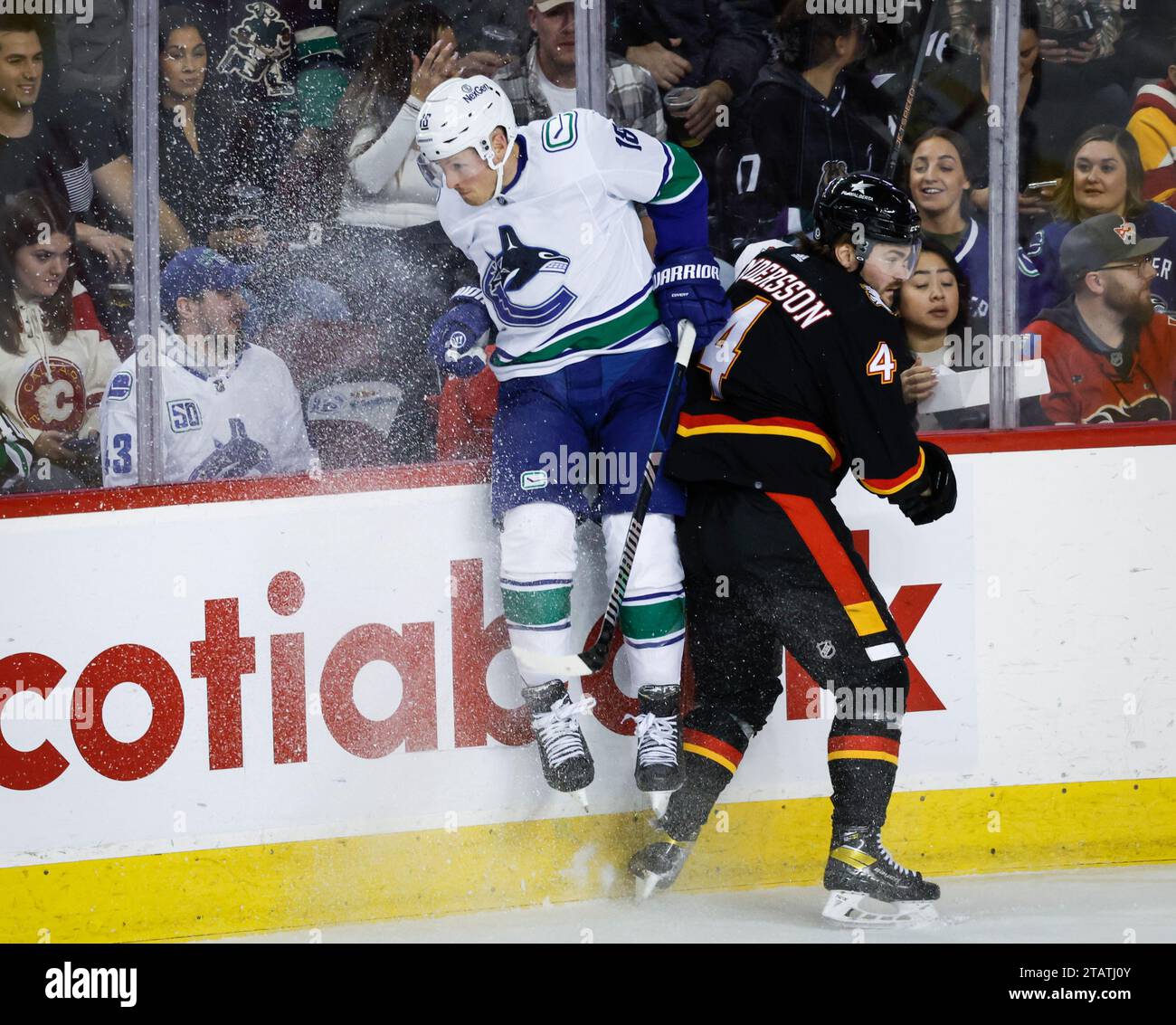Vancouver Canucks forward Sam Lafferty, left, is checked by Calgary ...