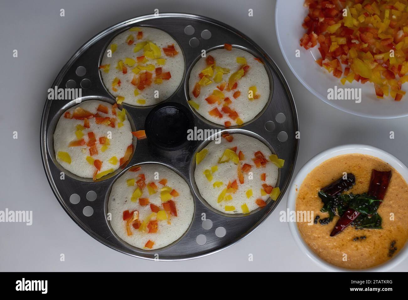 Savory bell pepper idly in idli mould, served with coconut chutney. A ...