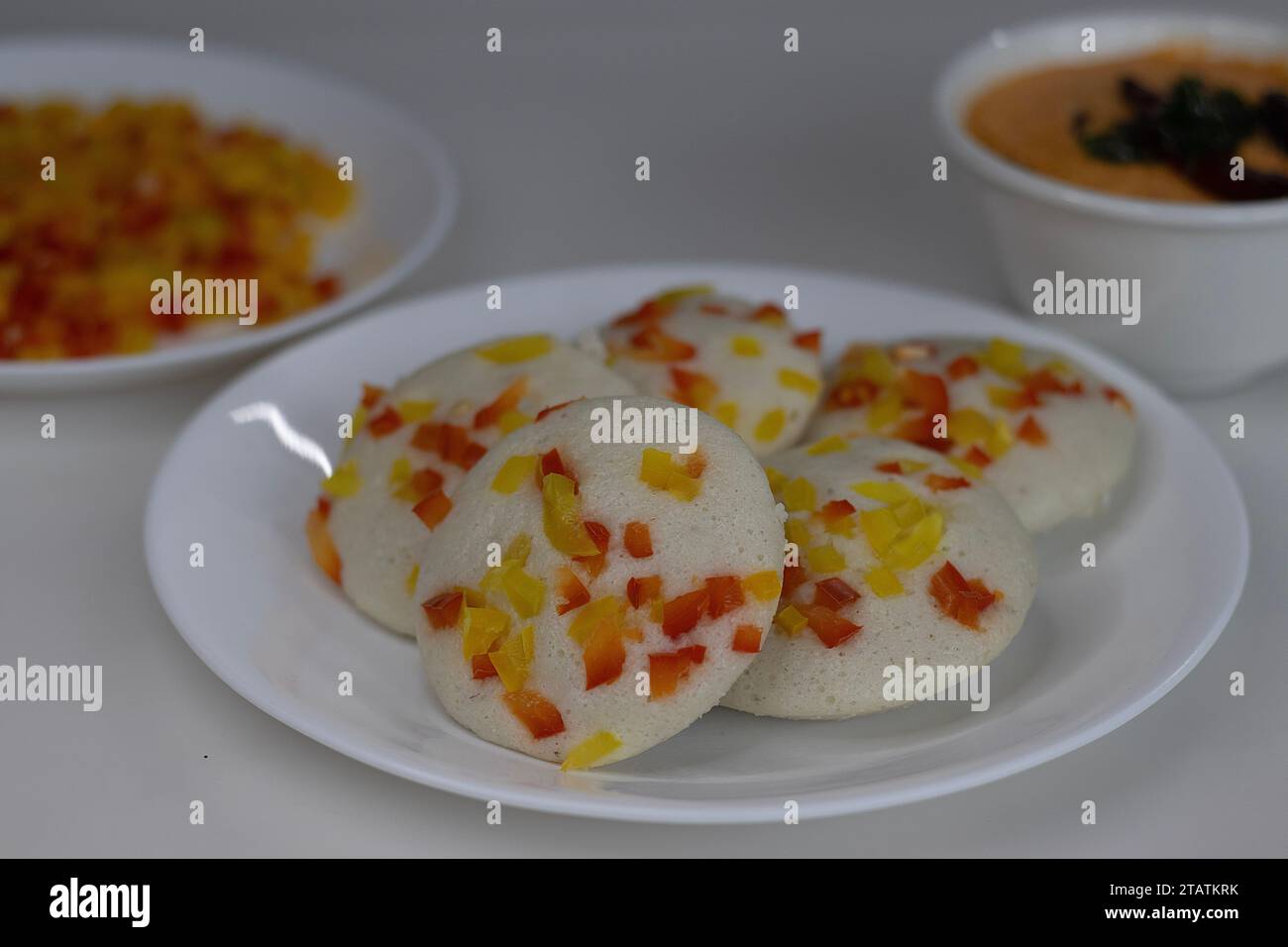 Savory bell pepper idly served with coconut chutney. A colorful and ...