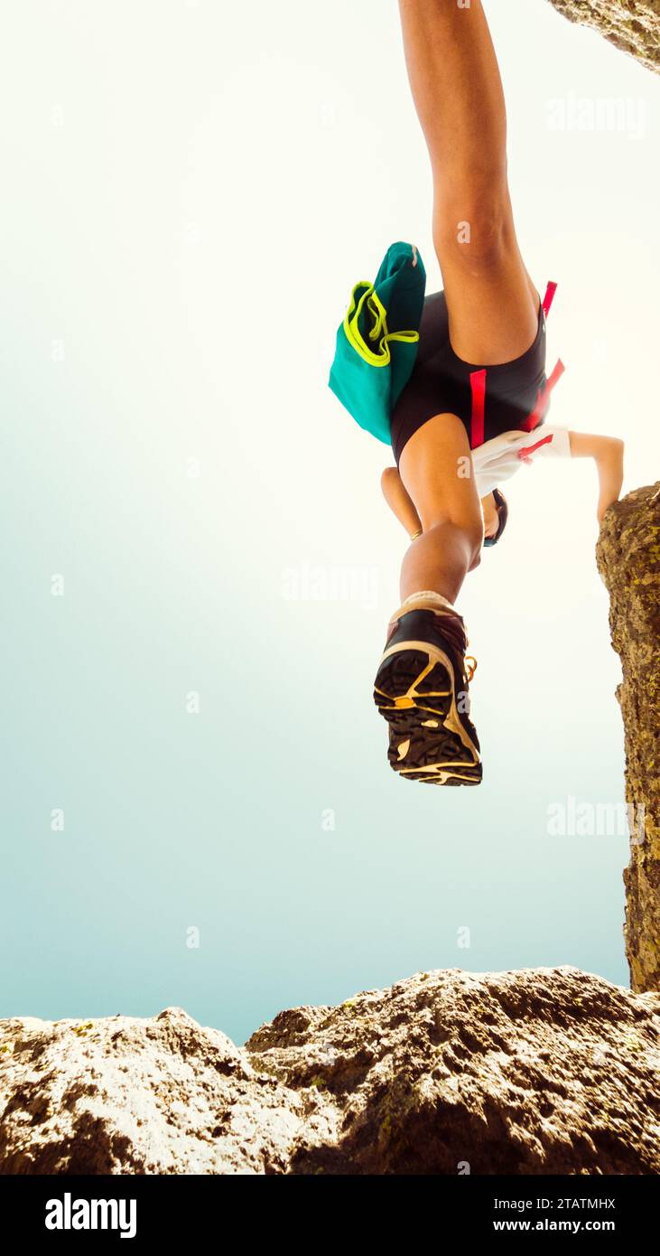 Low view female body step feet in air on hiking over rocks outdoors ...