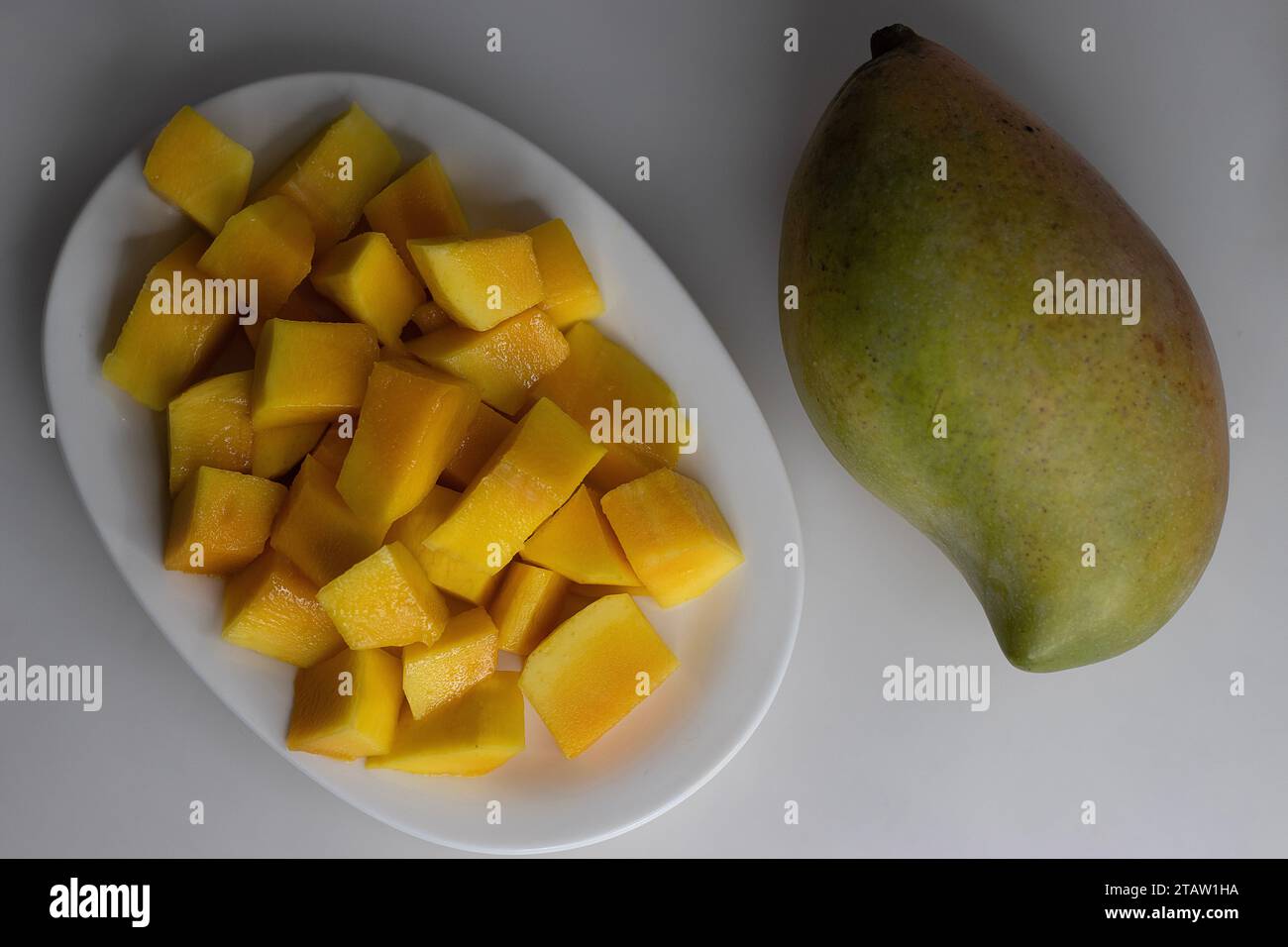 Fresh large totapuri mangoes sliced to small pieces, juicy and vibrant ...