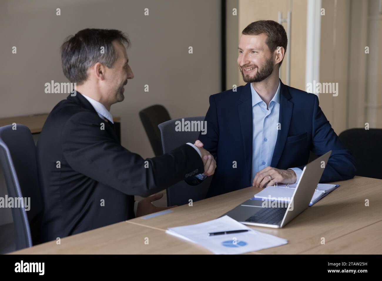 Two businessmen shake hands finish formal meeting in office Stock Photo ...