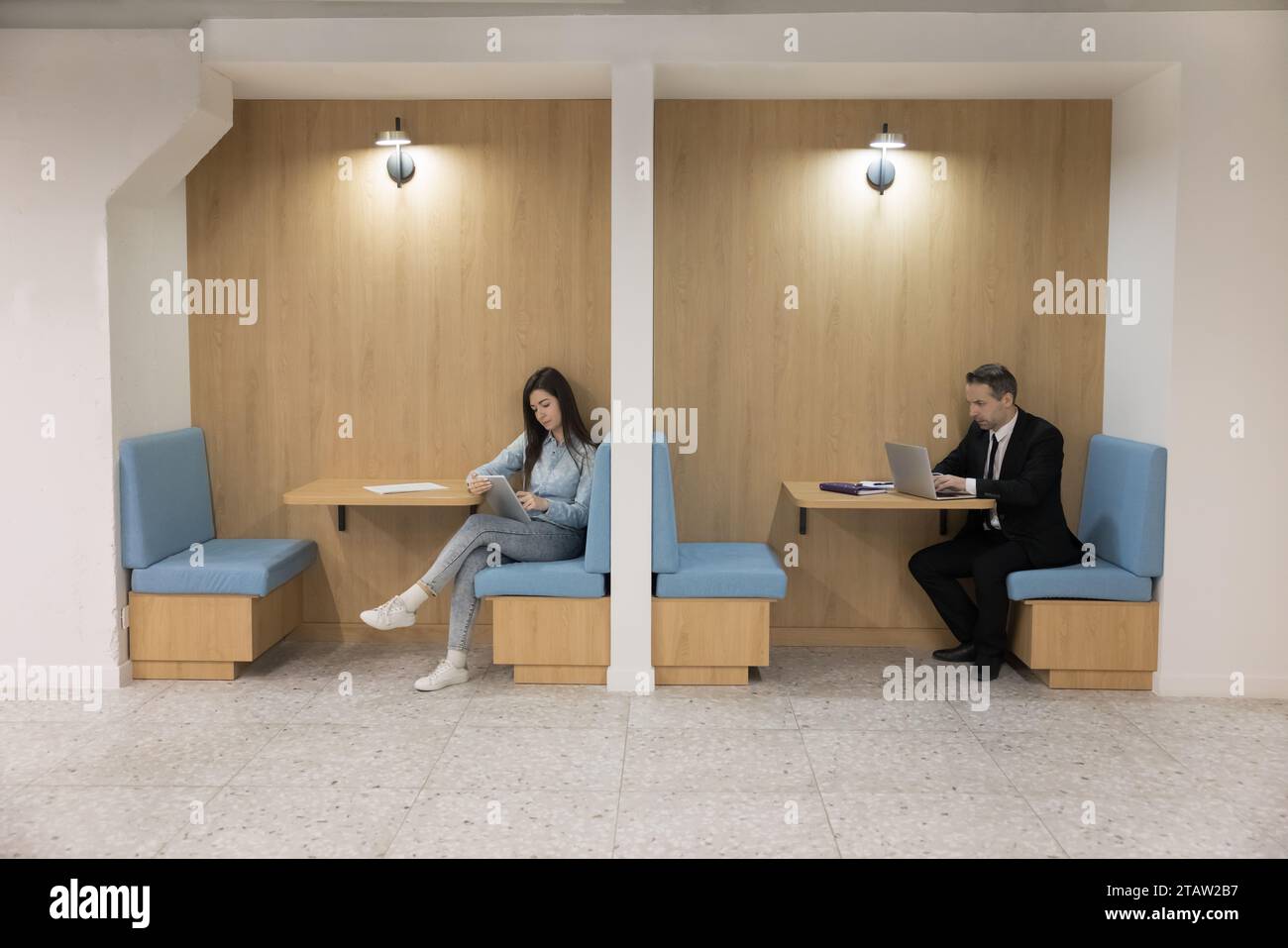 Two employees working seated in modern coworking space with partitions Stock Photo - Alamy