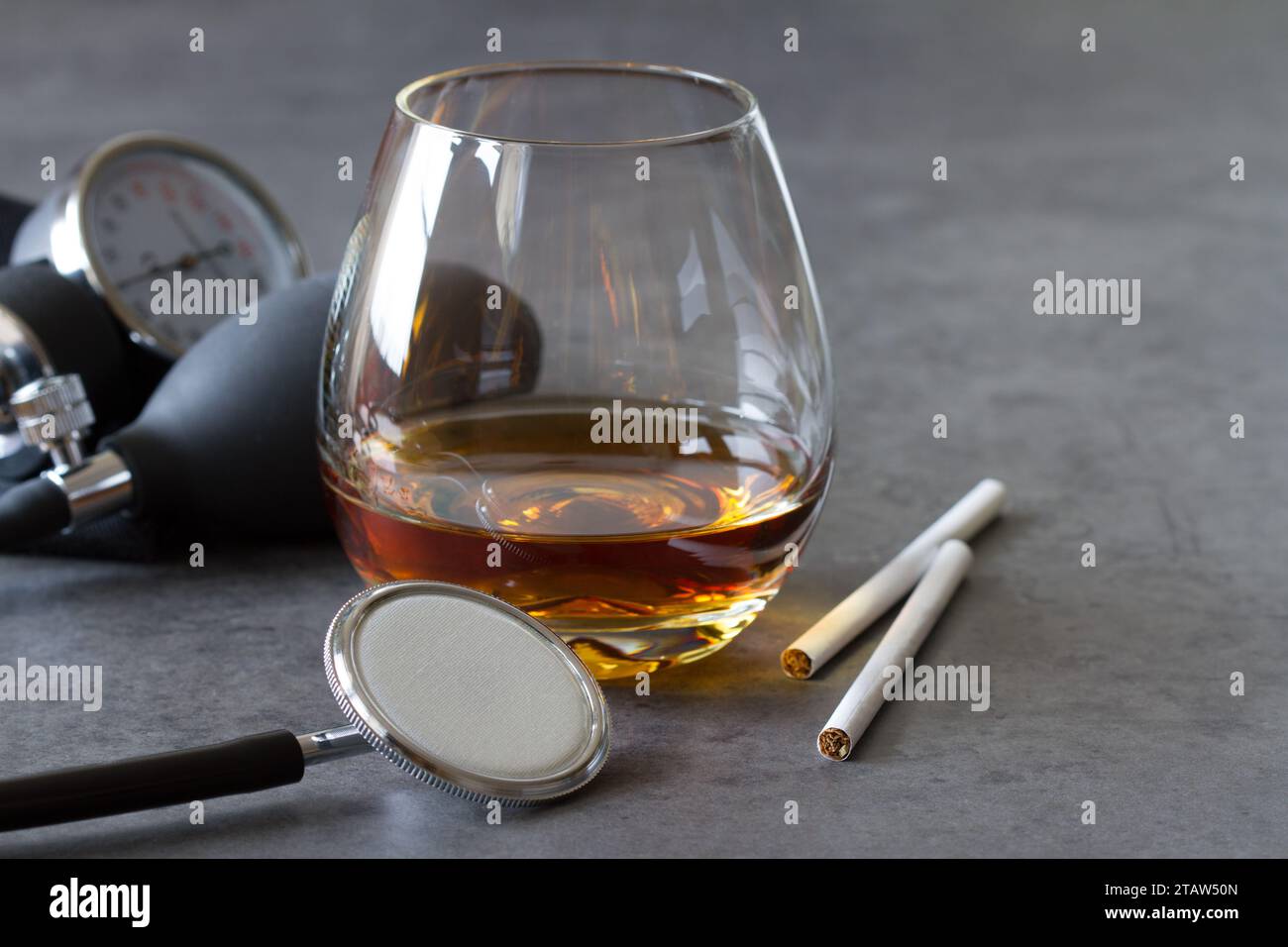 Glass of whiskey, cigarettes and blood pressure monitor, alcohol abuse ...