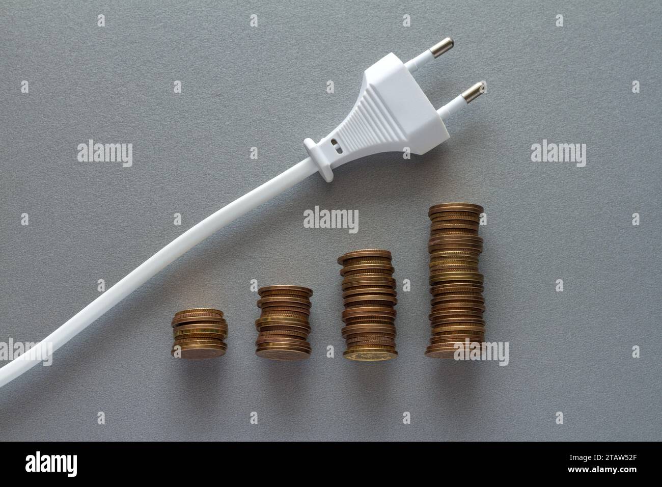Increasing energy bills costs, stacks of coins with cable with plug ...