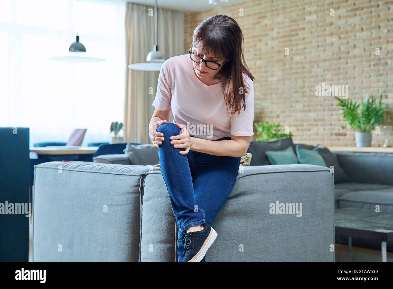 Middle aged woman suffering from knee pain Stock Photo - Alamy