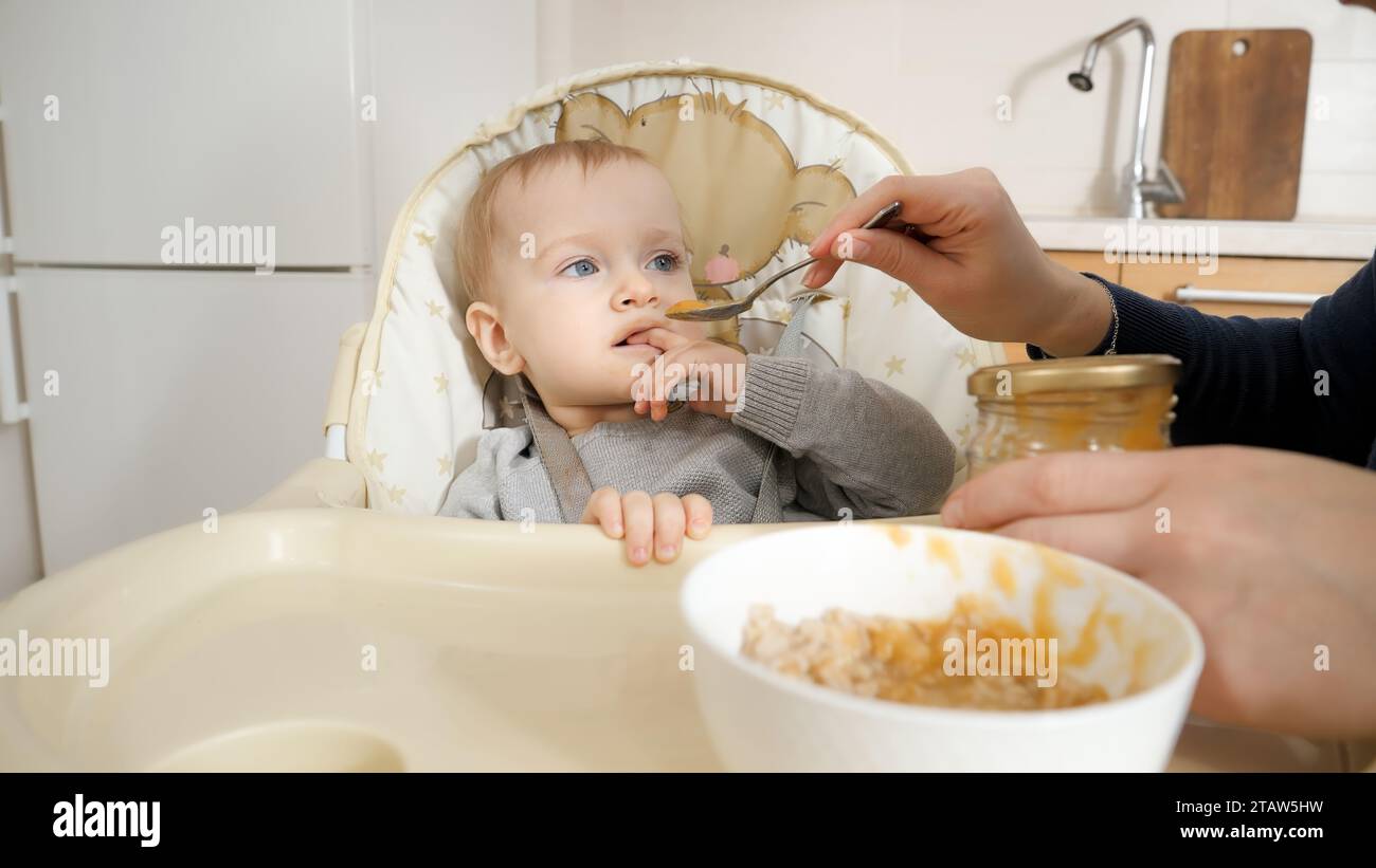 Cute little baby boy smiling at his mother while she is feeding him ...
