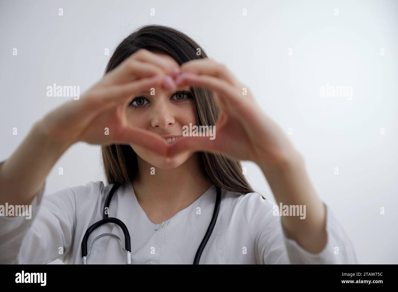 girl showing heart with hands young young doctor looking through hands ...