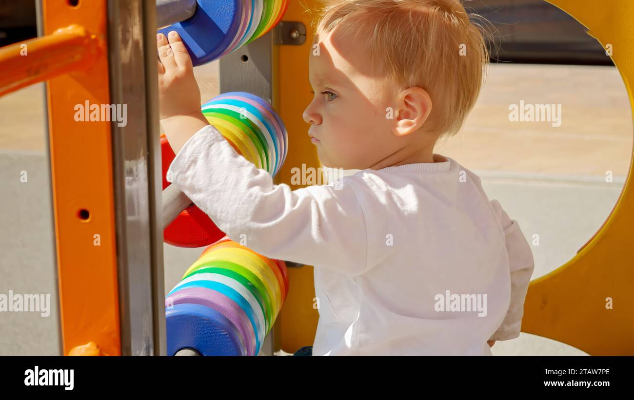 Cute baby learning how to use and play with colorful abacus. Children ...
