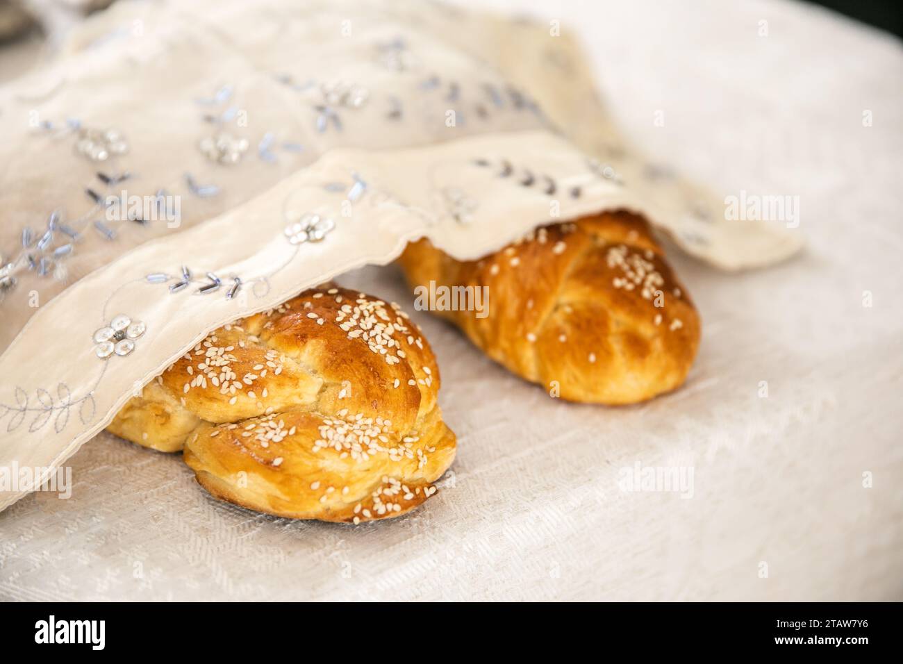 Challah bread with poppy and sesame seeds. Covered with white cover ...