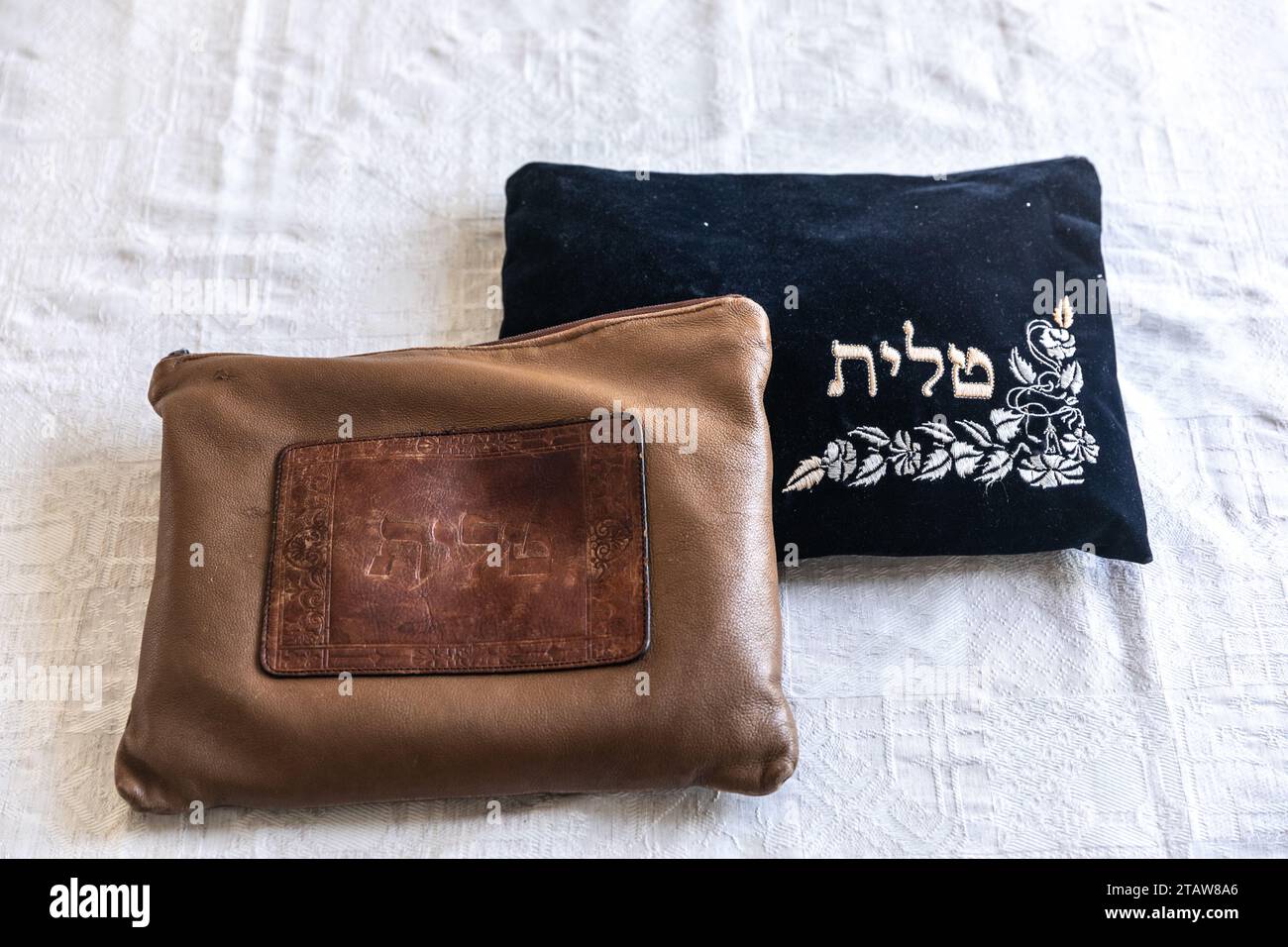 Two Tallit bags, saying "talit" in Hebrew on it, placed on a table ...
