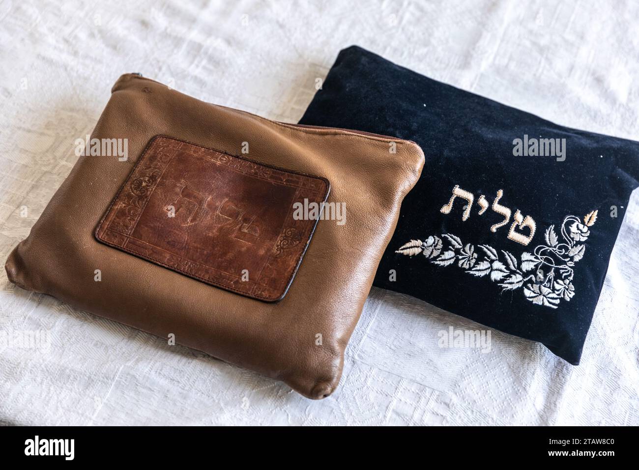Two Tallit bags, saying "talit" in Hebrew on it, placed on a table ...