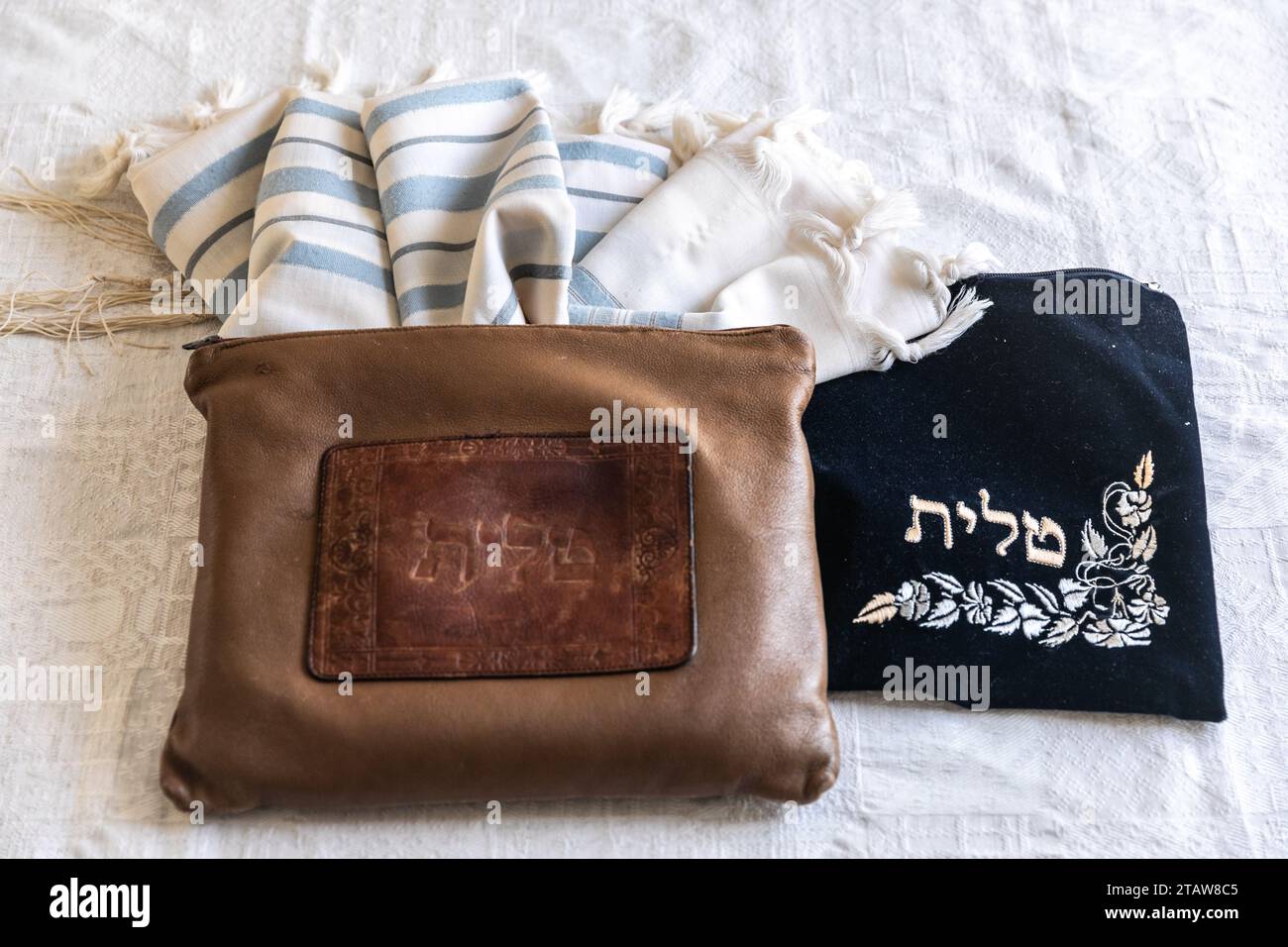 Two Tallit bags, saying "talit" in Hebrew on it, placed on a table ...