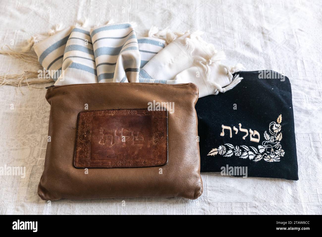 Two Tallit bags, saying "talit" in Hebrew on it, placed on a table ...