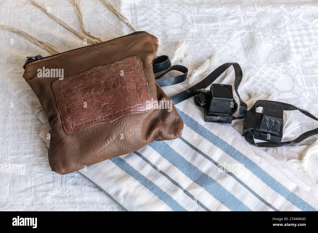A set of tefillin with verses from Torah written in them and a pouch ...