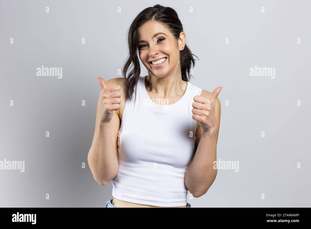 Joyful young woman make positive sign with her thumb up, positive mood ...
