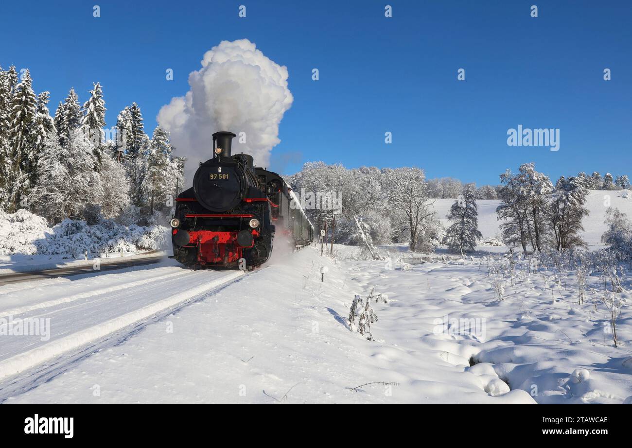 A steam locomotive moves through a snow blanketed landscape on the ...